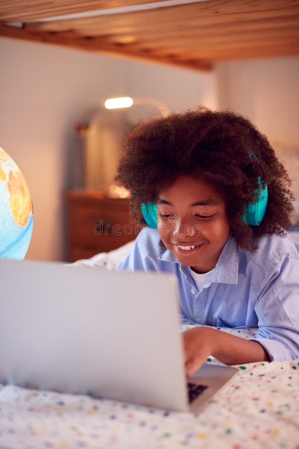 Boy in Bedroom at Night Lying on Bed Using with Laptop with Illuminated ...