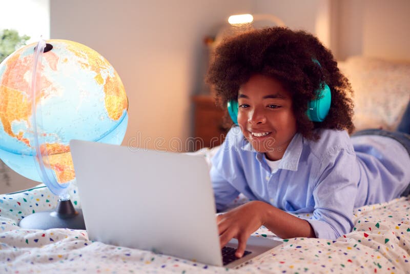 Boy in Bedroom at Night Lying on Bed Using with Laptop with Illuminated ...