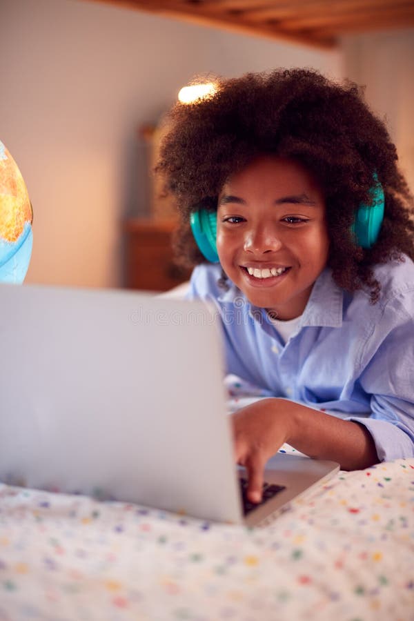 Boy in Bedroom at Night Lying on Bed Using with Laptop with Illuminated ...