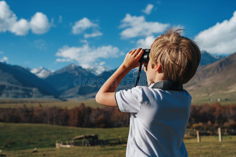Boy with Binoculars in the Mountains Looking into the Distance Stock ...