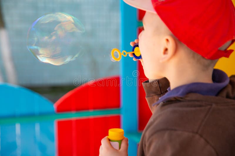 Boy Blowing the Big Soap Bubble Outdoors. Close Up Stock Photo - Image ... Boy Blowing the Big Soap Bubble Outdoors. Close Up Stock Photo - Image ...