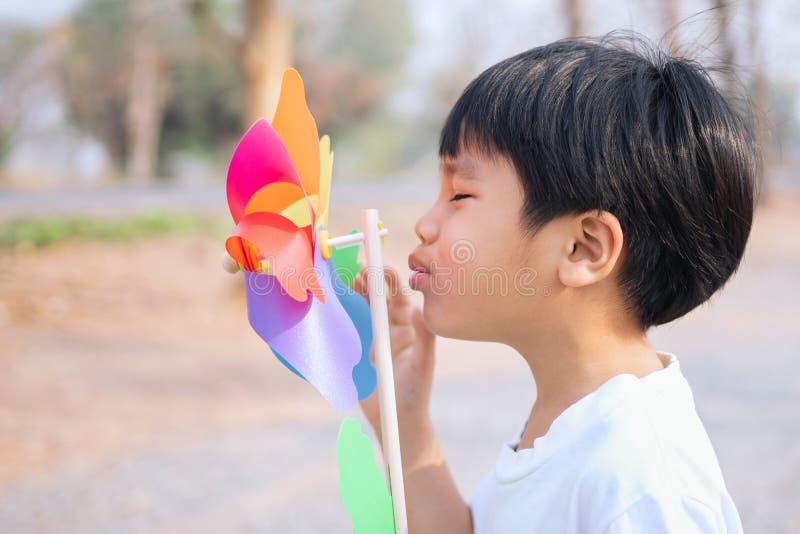 Boy Blowing a Toy Windmill in the Morning Stock Image - Image of nature ...
