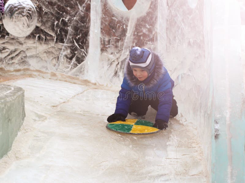 A Boy in a Blue Jacket Riding an Ice Slide Stock Image - Image of cold ...