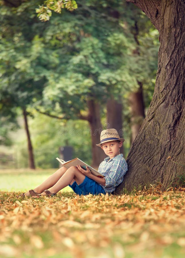 Boy with Book Sitting Under Big Tree in Park Stock Image - Image of ...