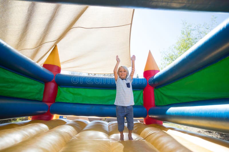 Boy Bouncing Inside Brightly Colored Inflatable Bounce Castle Under ...