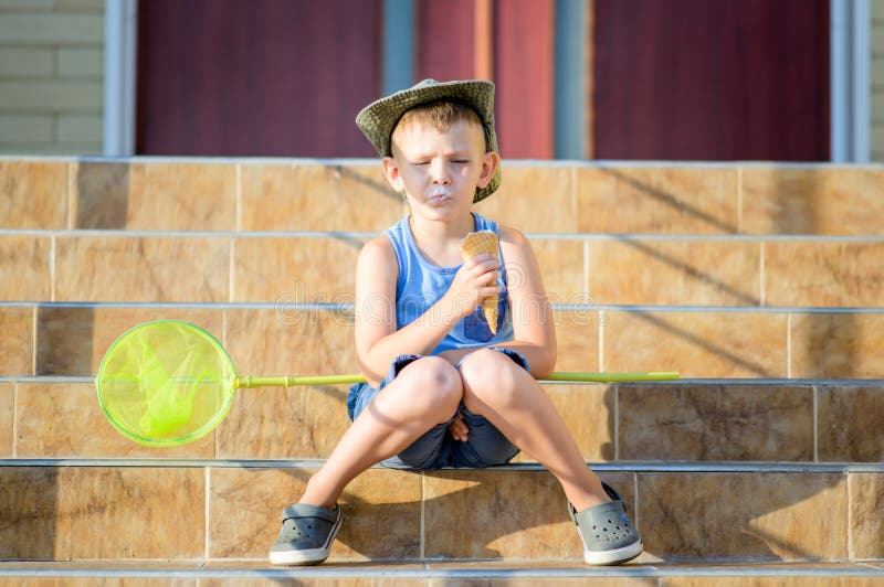 Boy with Bug Net Eating Ice Cream on Steps of Home Stock Photo - Image ...