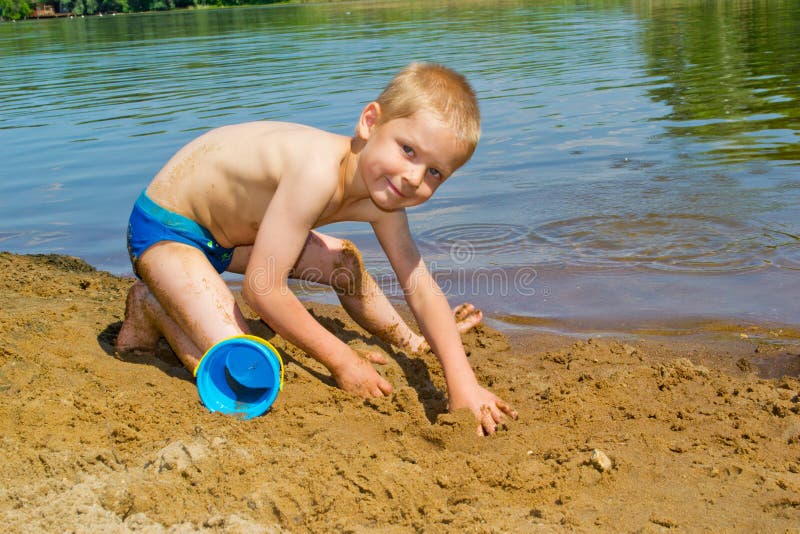 Boy in sand on seashore stock image. Image of sunbathe - 6101953