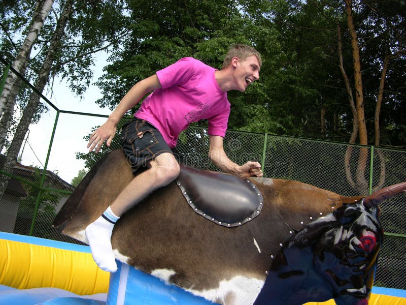 Boy on bull simulator stock image. Image of bovine, cowboy - 1375211
