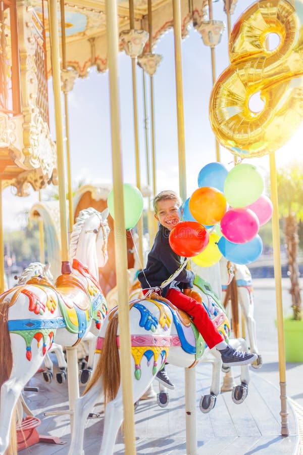 Boy with Bunch of Colorful Balloons on the Carousel in Paris. Stock ...