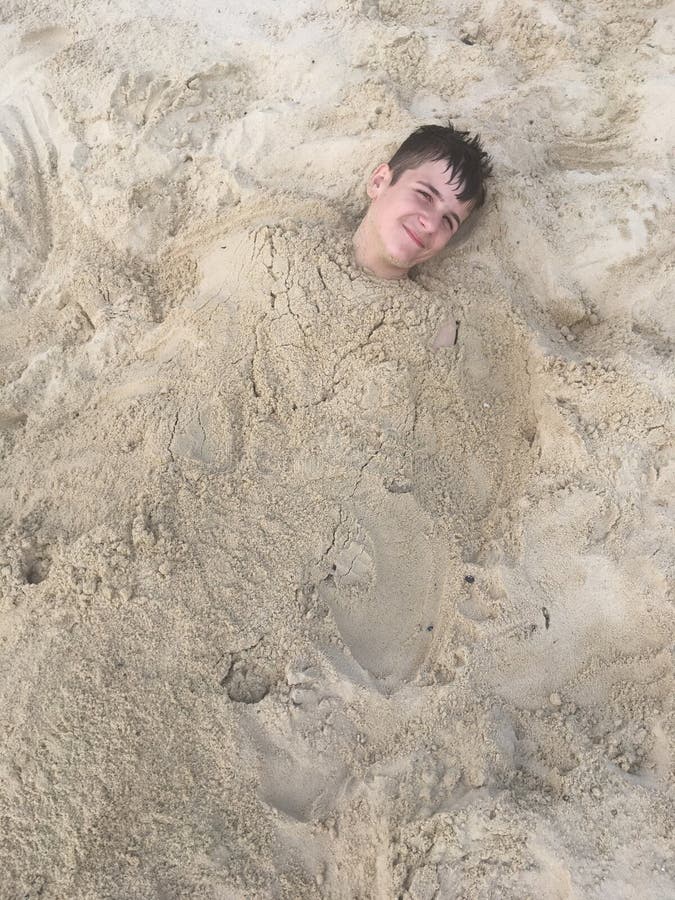 Boy burried in sand stock image. Image of caucasian - 148794461