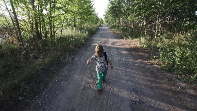 A Boy in a Cap with a Stick Walks Stock Video - Video of goal, grass ...