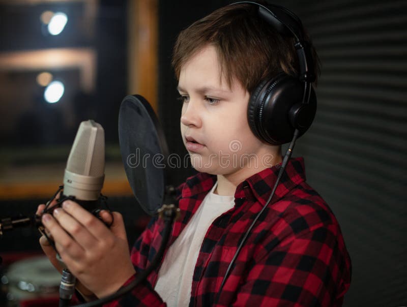 Boy in Check Shirt and Headphone is Singing or Talking into Microphone ...