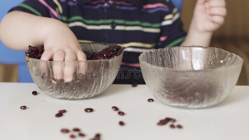 Boy child is playing beans stock footage. Video of home - 182152584