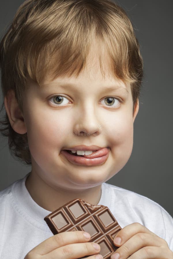 Boy with chocolate bar stock photo. Image of indoors - 64634696