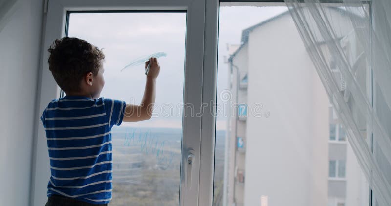 A Boy Cleans a Window, Captivated by the Oceans Rhythmic Waves Stock ...