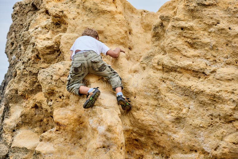 Boy climbing on the rock stock image. Image of happiness - 115188691