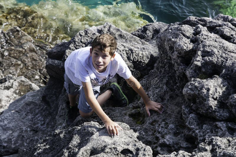 Boy climbing rocks stock photo. Image of outdoors, climbing - 58621430