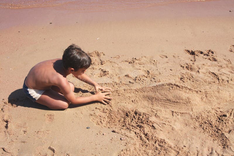 Boy Constructing a Figure on the Sand. Stock Photo - Image of tanned ...