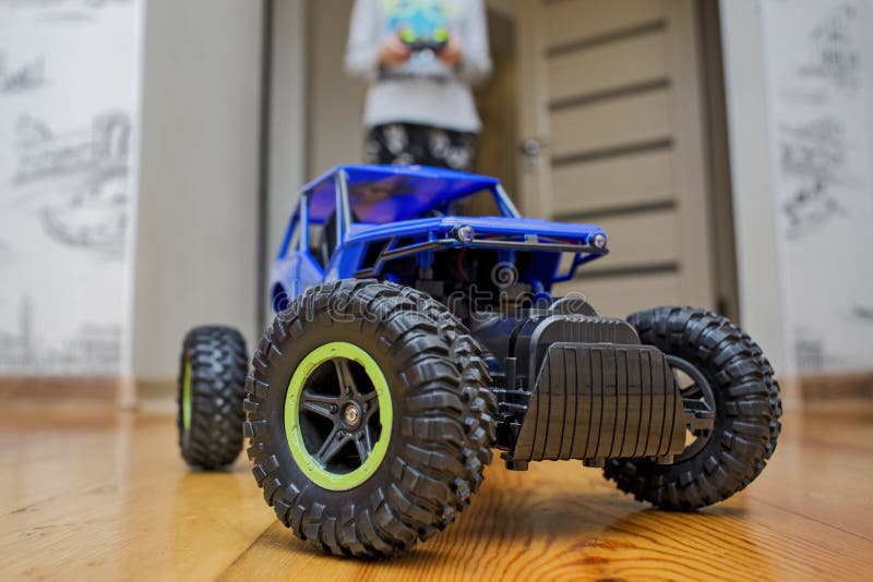 The Boy is Controling the Blue Toy Car with a Remote Control. Child ...