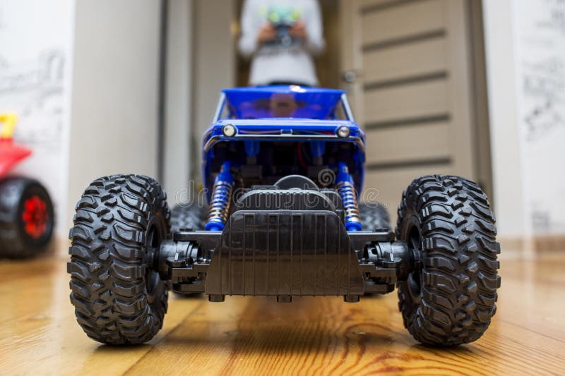 The Boy is Controling the Blue Toy Car with a Remote Control. Child ...