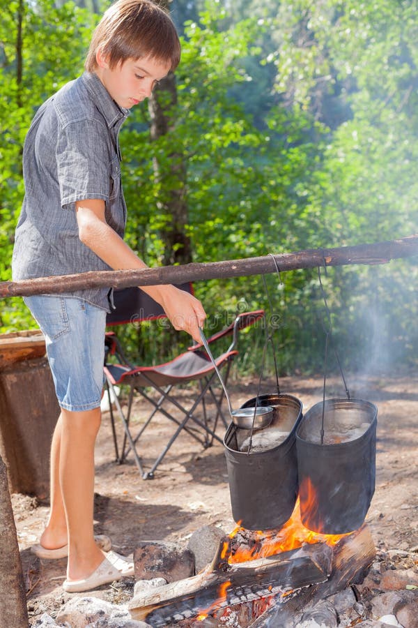 Child cooking on campfire stock photo. Image of kettle - 66521344