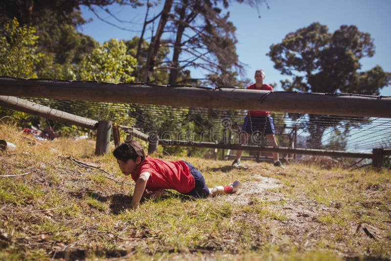 Boy Crawling Under the Net during Obstacle Course Training Stock Photo ...