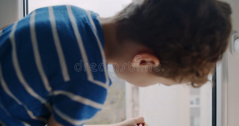 A Boy Creatively Draws on a Window with Chalk, Expressing Curiosity ...