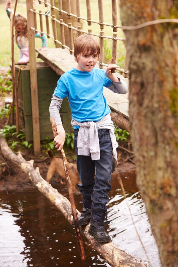 Boy Crossing Stream Balancing on Log at Activity Centre Stock Photo ...