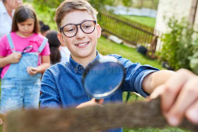Boy Curiously Examines a Piece of Tree Bark Stock Photo - Image of ...