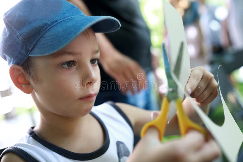 Boy Cuts Out Figure with Scissors Stock Photo - Image of blank ...