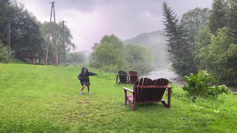 Boy Dancing in the Rain Against the Background of a Mountain Landscape ...