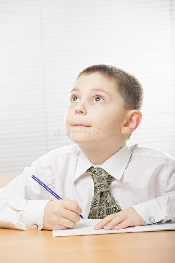 Boy at desk looking up stock photo. Image of thoughtful - 26461746