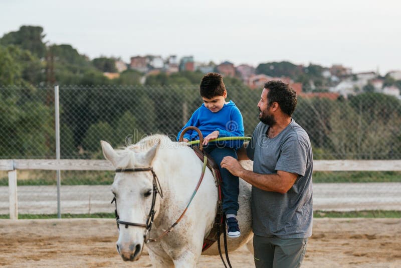 Boy with Disabilities Riding a Horse while Having an Equine Therapy ...