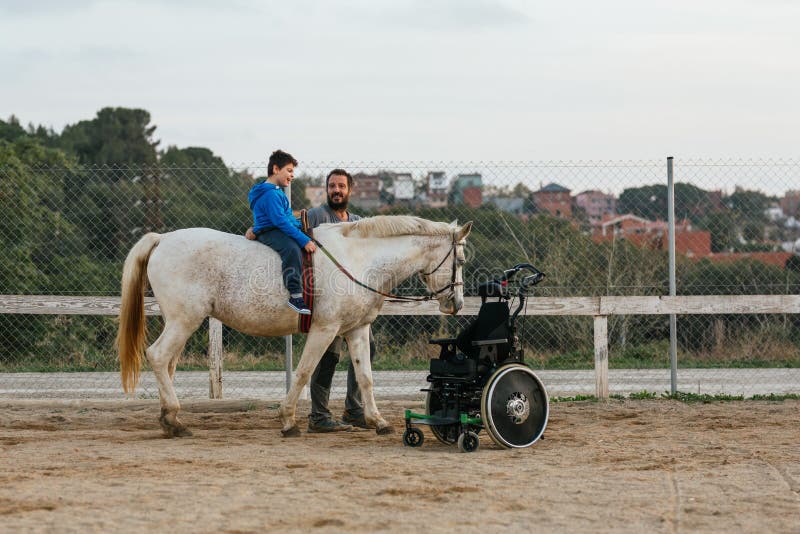 Boy with Disabilities Riding a Horse while Having an Equine Therapy ...