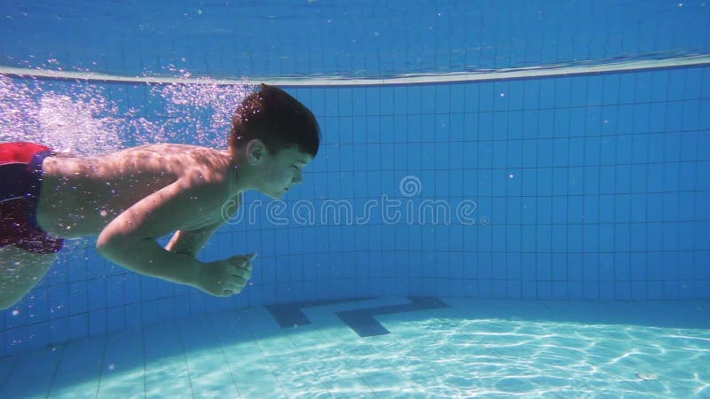 Boy dive in swimming pool stock video. Video of diver - 117181699