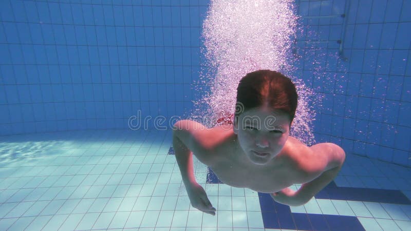 Boy dive in swimming pool stock video. Video of diver - 117181699