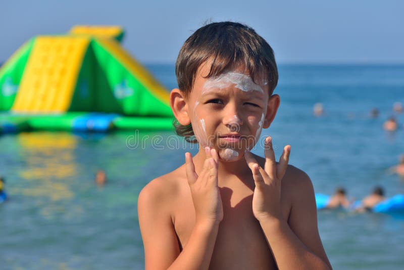 Boy does sunscreen on face stock photo. Image of outdoors - 76100222