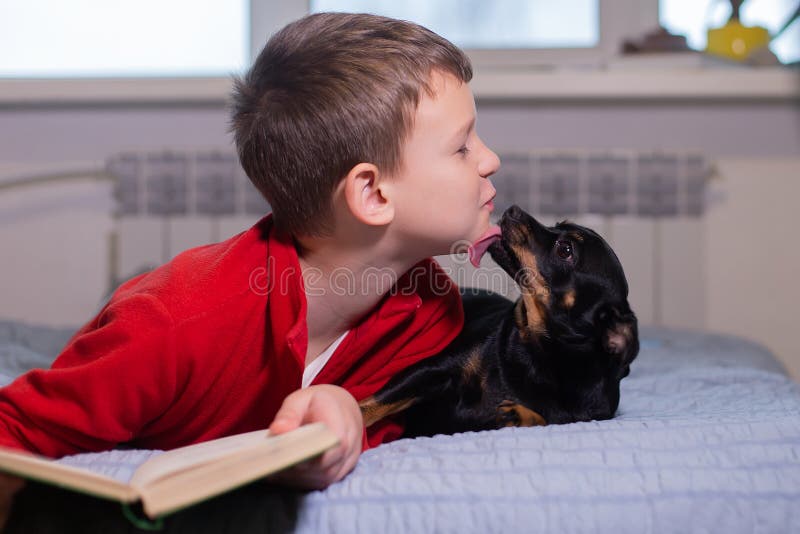 Boy with dog reads a book stock image. Image of emotion - 201110663