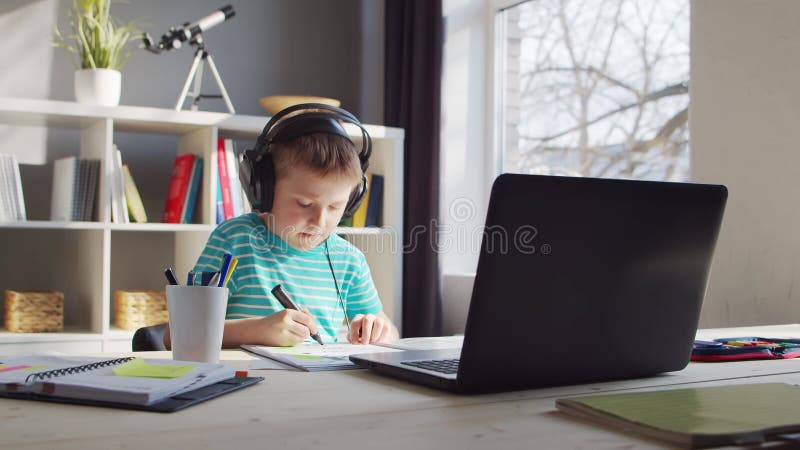 Boy is Doing His Homework at the Table. Cute Child is Learning at Home ...