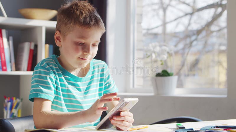 Boy is Doing His Homework at the Table. Cute Child is Learning at Home ...