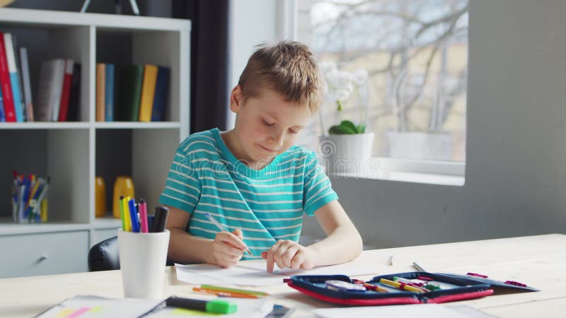 Boy is Doing His Homework at the Table. Cute Child is Learning at Home ...