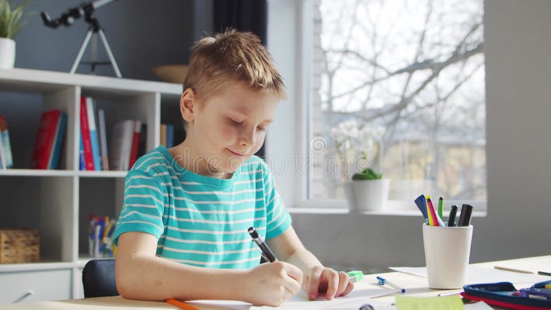 Boy is Doing His Homework at the Table. Cute Child is Learning at Home ...