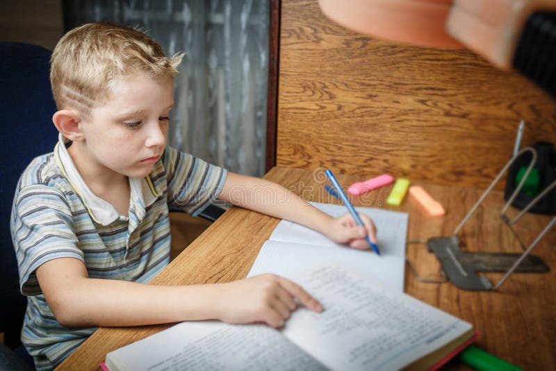Boy doing homework at home stock photo. Image of book - 199285060