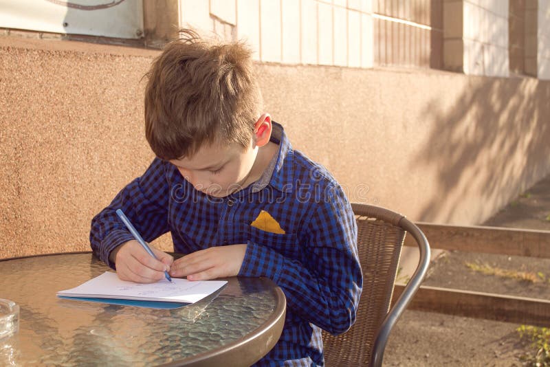 Boy is Doing Homework Outdoors Stock Image - Image of child ...