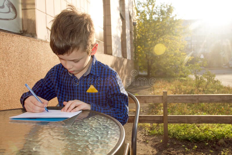 Boy is Doing Homework Outdoors Stock Image - Image of person, children ...
