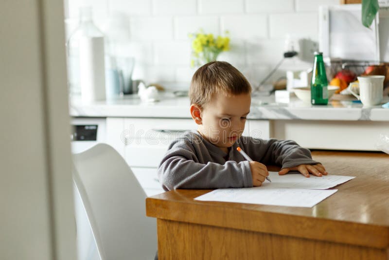 Boy Doing Homework Sitting at Kitchen Table Stock Image - Image of male ...