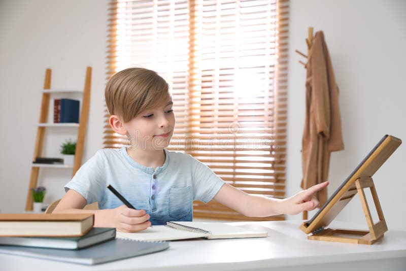 Boy Doing Homework with Tablet at Table Stock Image - Image of computer ...