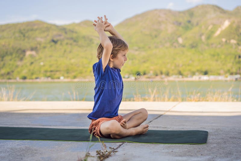 Boy Doing Yoga on a Yoga Mat Against a Background of Mountains Stock ...