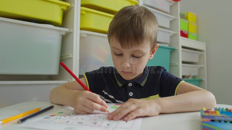 A Boy Draws on a Sheet while Doing Logic Tasks at School. Stock Video ...