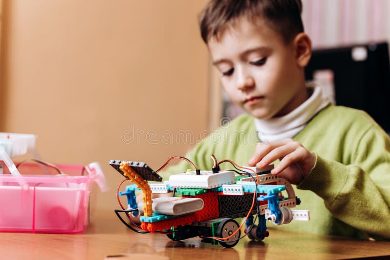 Boy Dressed in Green Sweater Sits at the Desk with Computer and Looks ...